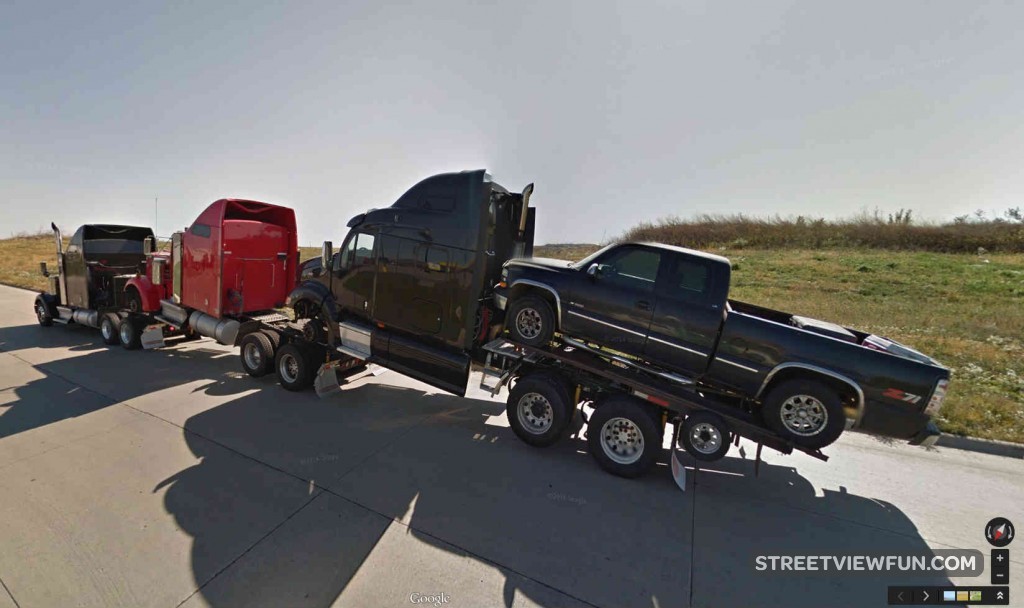 A truck carrying a truck carrying a truck carrying a pickup truck ...